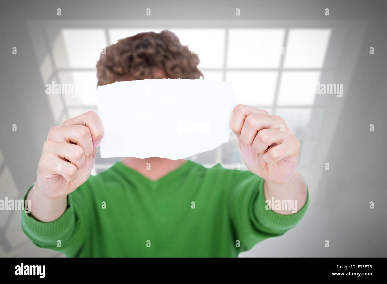 Composite image of man holding blank paper in front on face Stock Photo ...