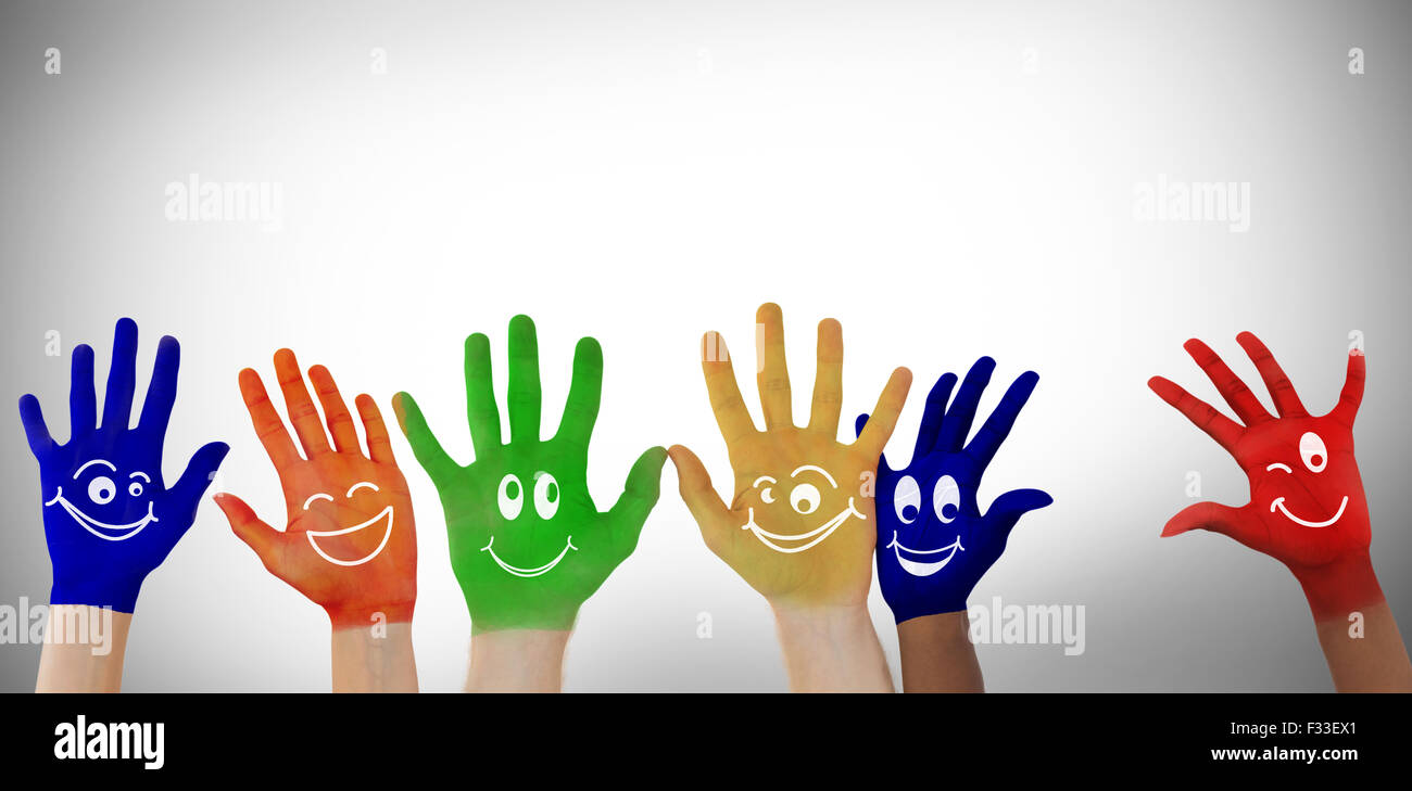 Composite image of hands with colourful smiley faces Stock Photo - Alamy