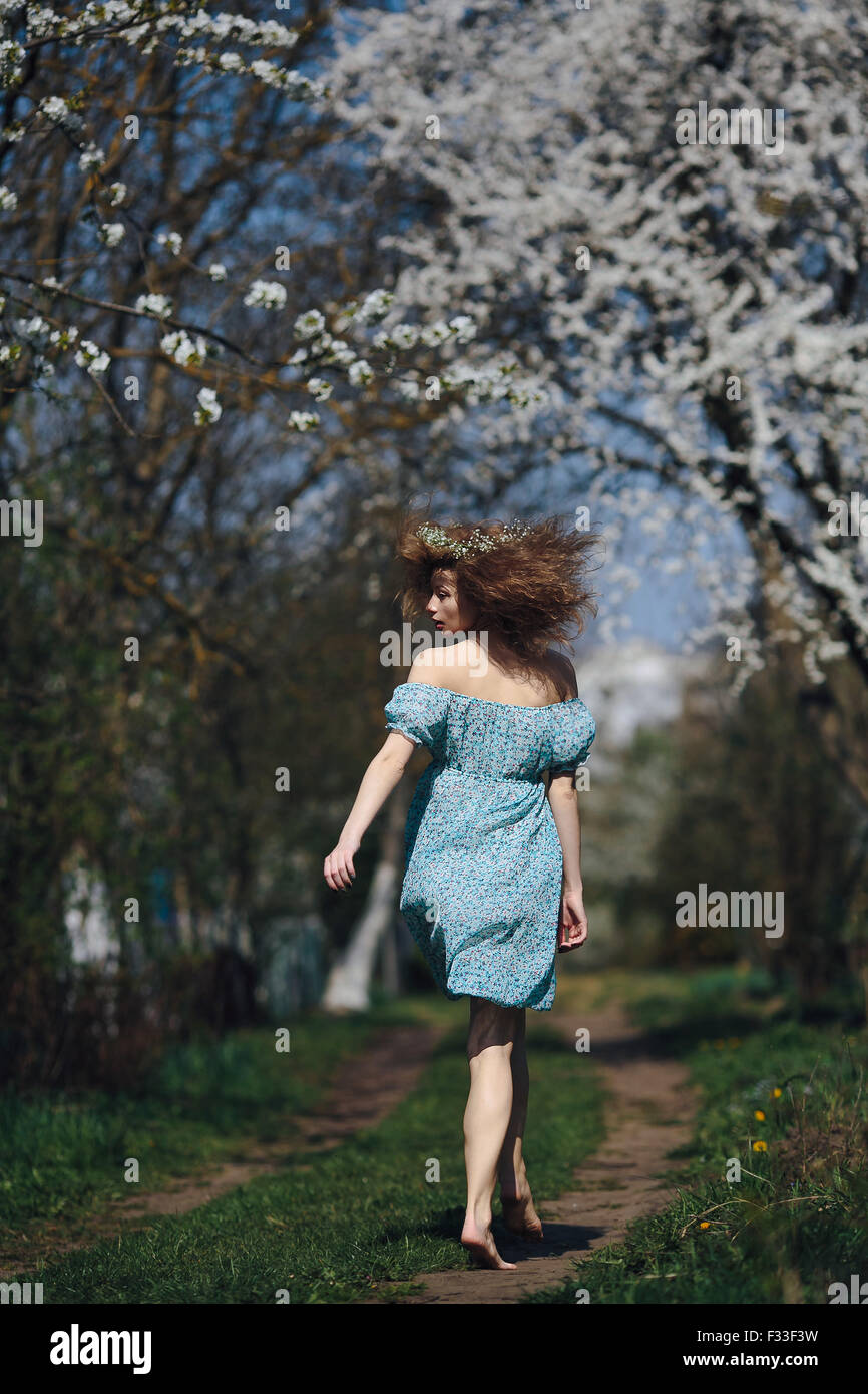 Beautiful girl follows a country road Stock Photo - Alamy