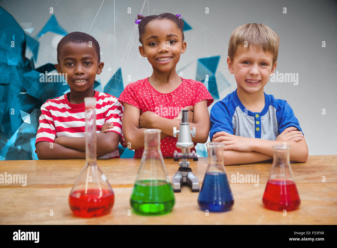 Composite image of cute pupils standing with arms crossed behind beaker ...