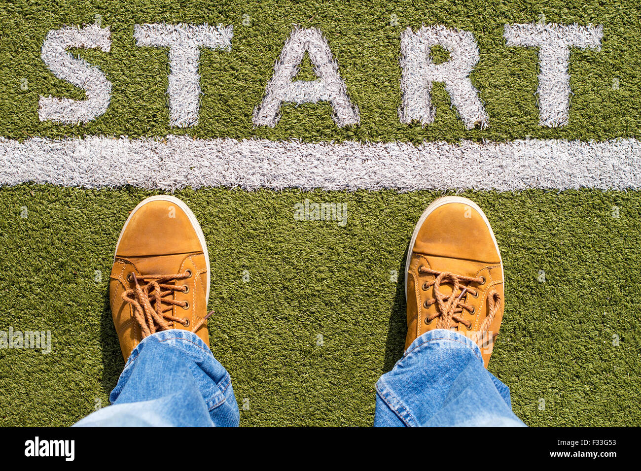 Man's legs behind the white line from above with START sign Stock Photo ...