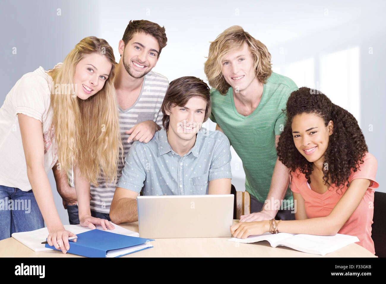 Composite image of college students using laptop in library Stock Photo ...