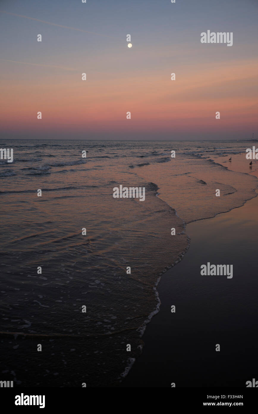 Full moon over Brighton beech at sunrise Stock Photo - Alamy
