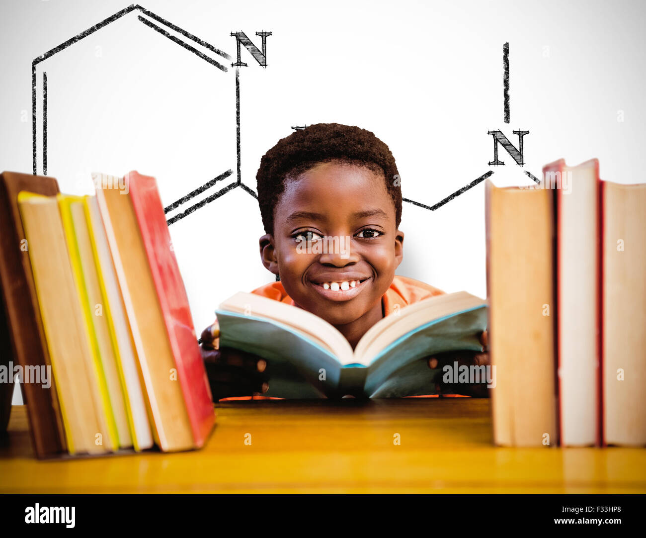 Composite image of cute boy reading book in library Stock Photo - Alamy