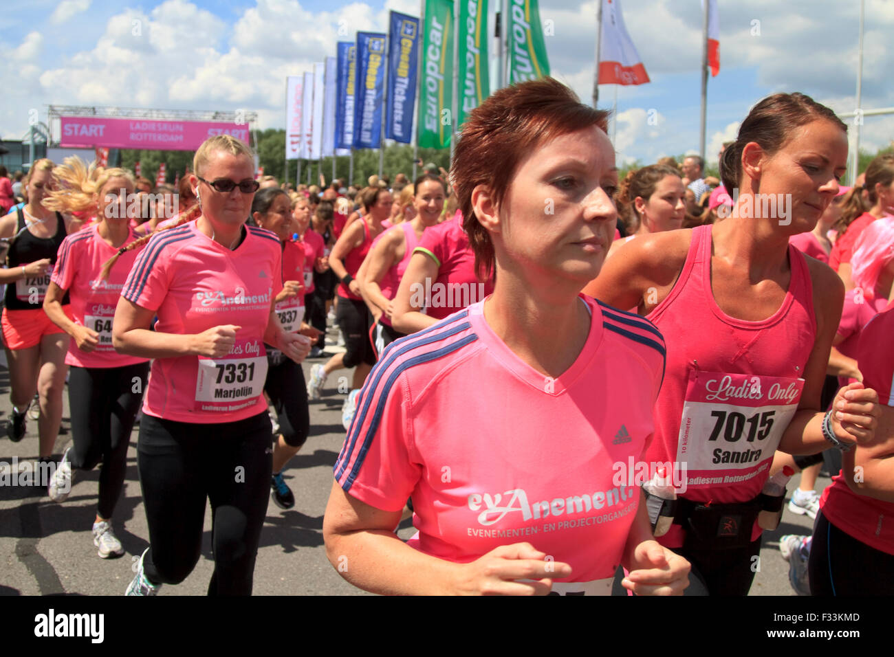 Female runners dressed in pink passing close bye running in the annual ...