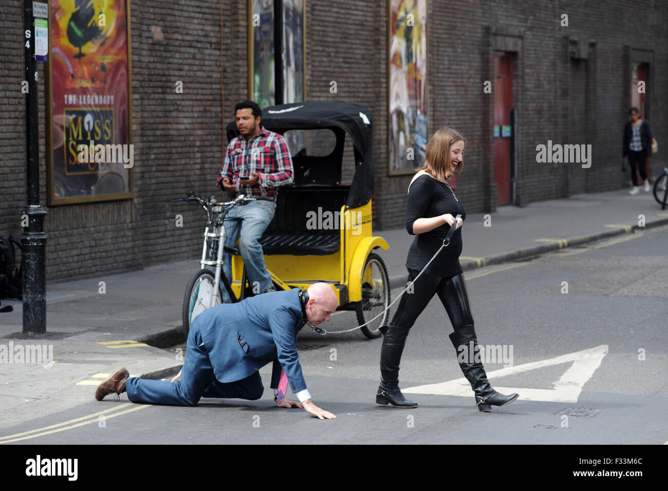A man being publicly humiliated by a dominatrix in the streets of Soho ...