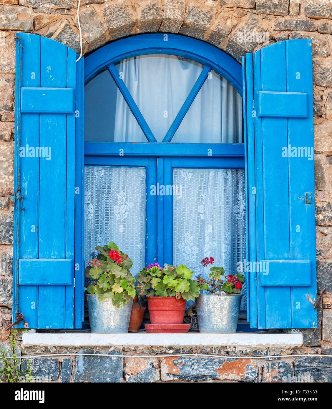 Colourful window with flower pots set in a stone wall Stock Photo - Alamy