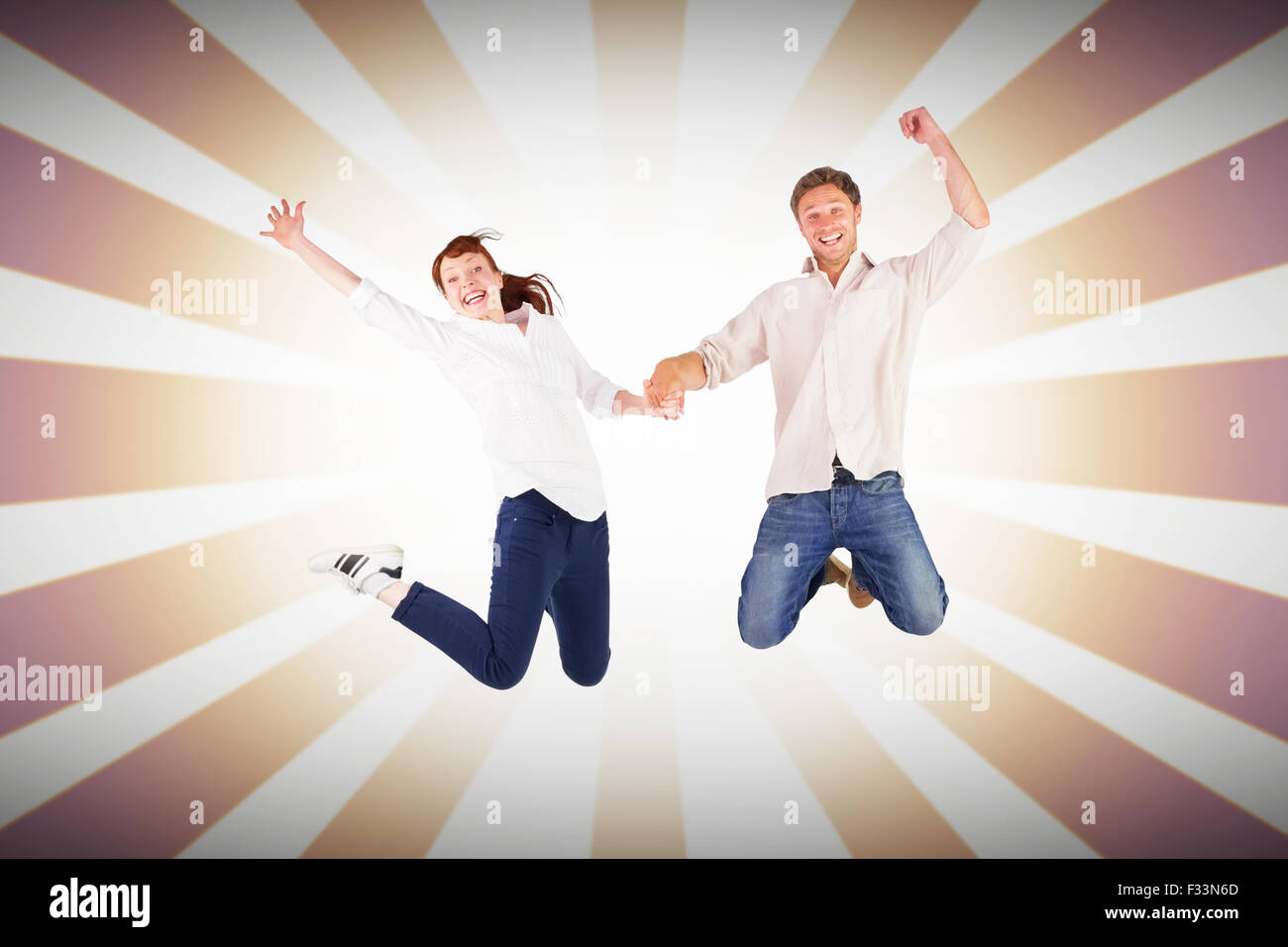 Composite image of couple jumping and holding hands Stock Photo - Alamy