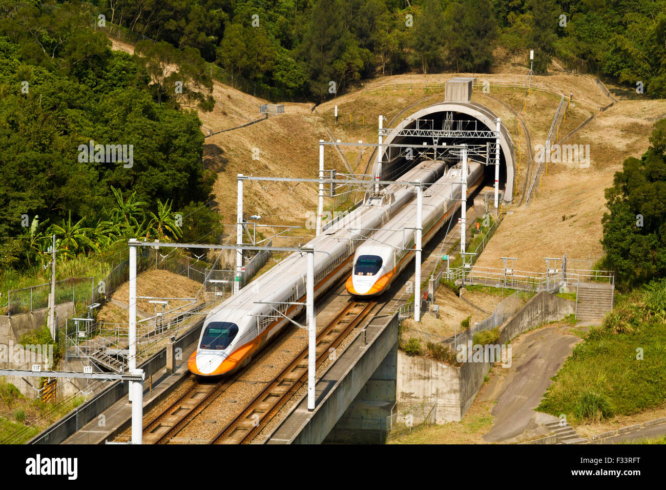 high speed commuter train driving across tunnel with mountain scenery ...