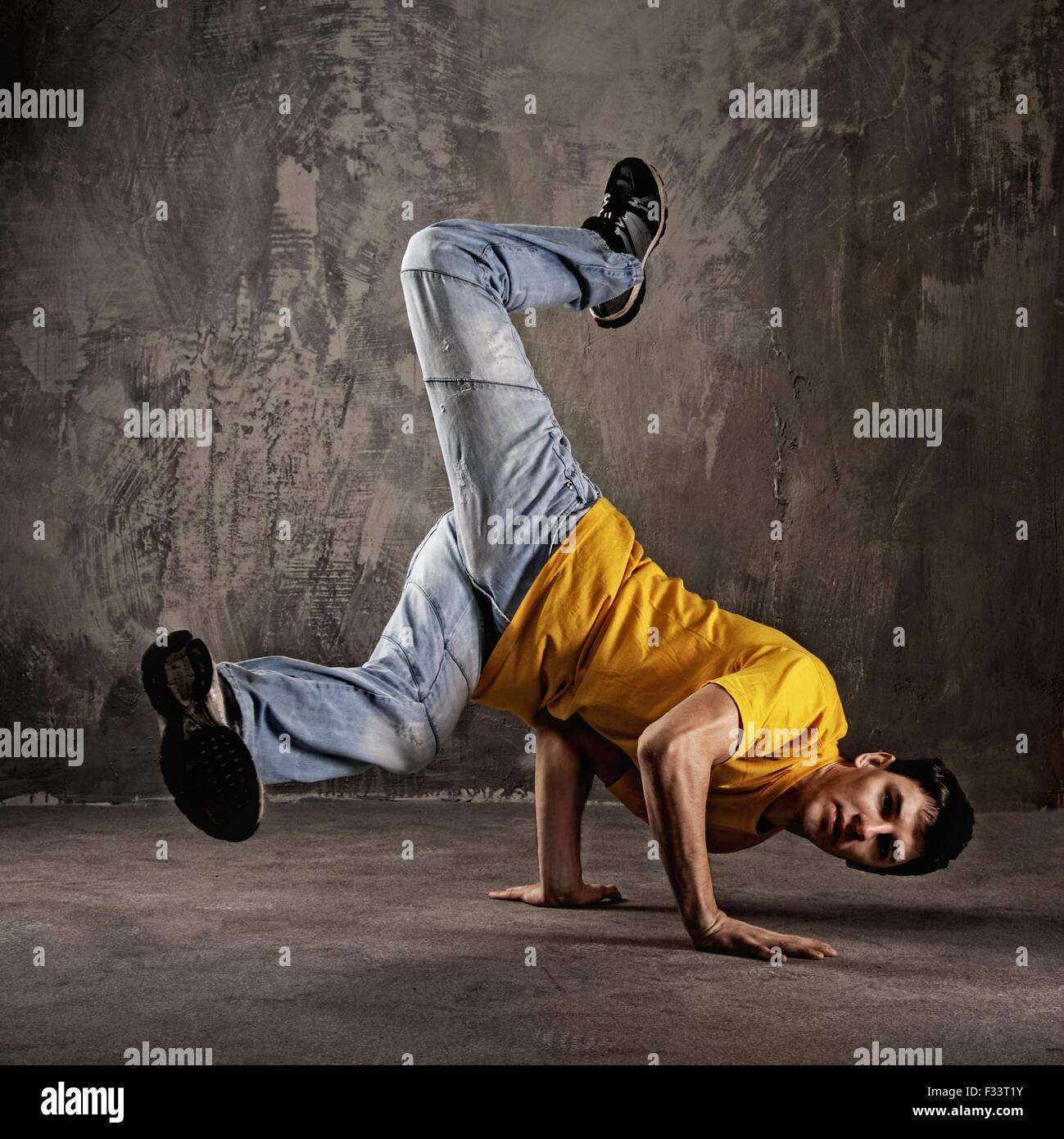 Young man dancing against grunge wall Stock Photo - Alamy