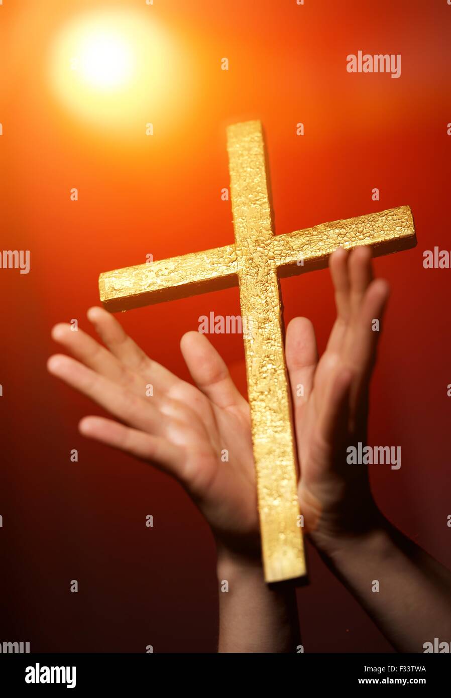 Golden cross in human hands Stock Photo - Alamy