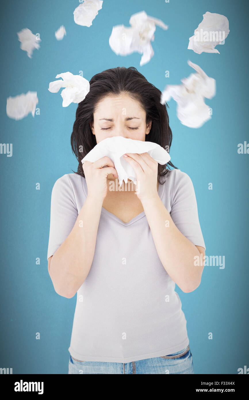 Composite image of sick brunette blowing her nose Stock Photo - Alamy