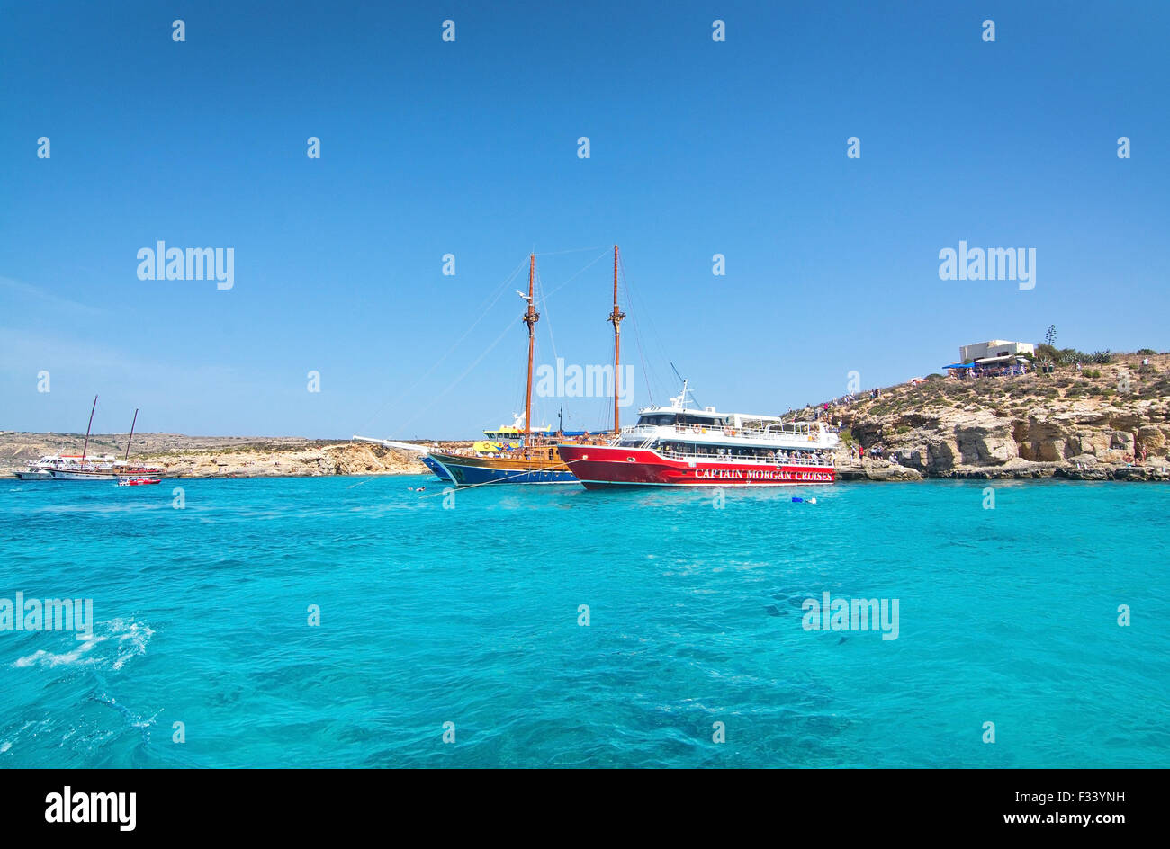 Tour boats in the clear turquoise water and arid landscape of popular ...
