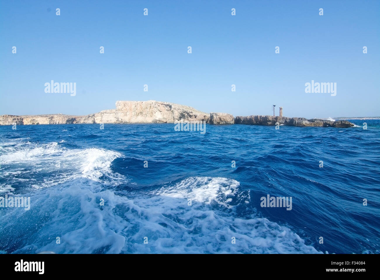 Limestone rock with caves and blue Mediterranean ocean water near ...