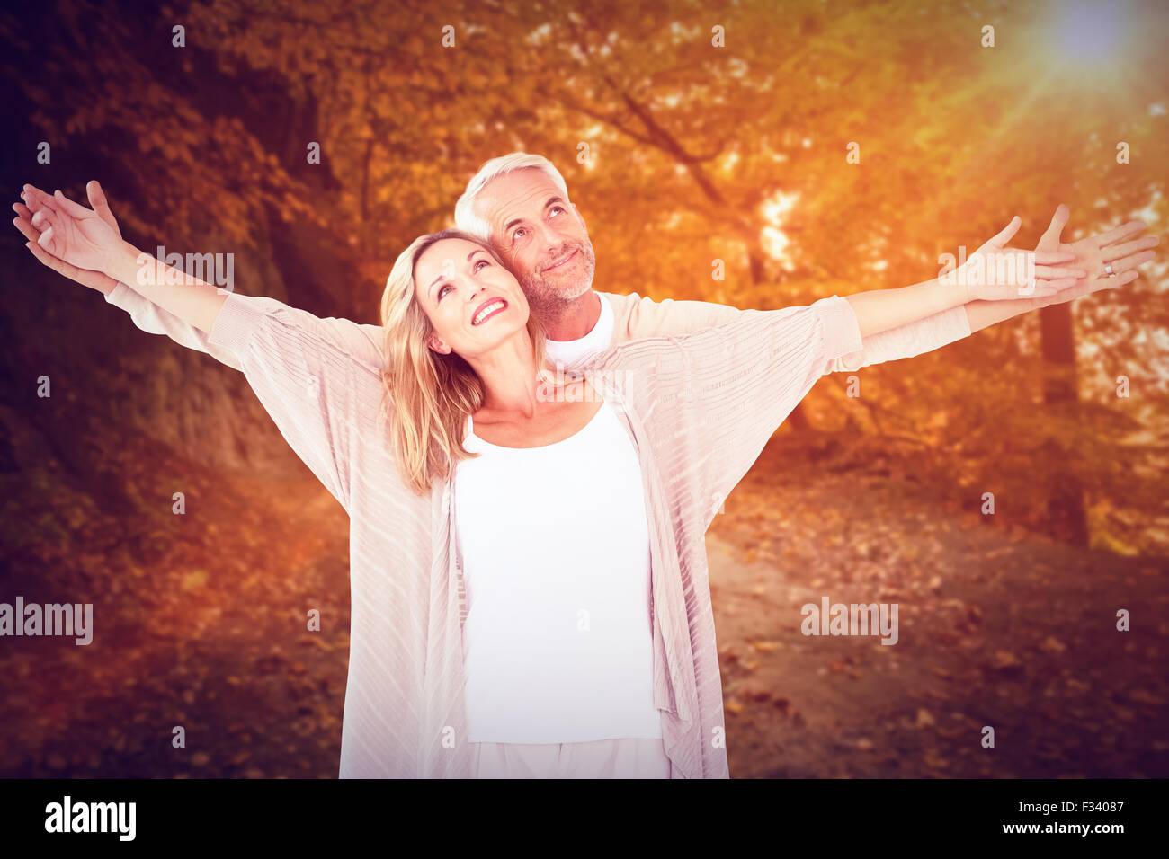 Composite image of cheerful couple with arms outstretched Stock Photo ...