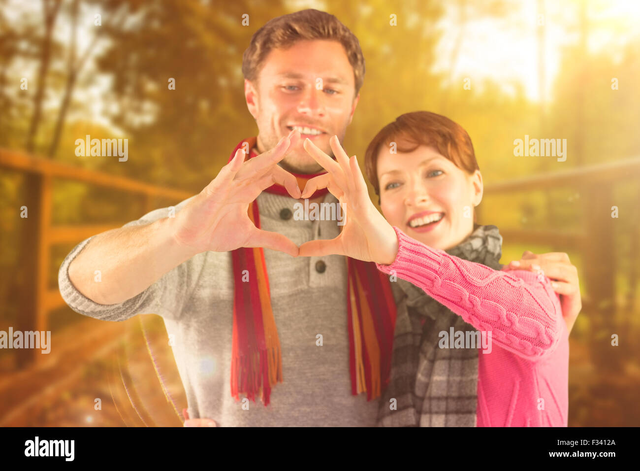 Composite image of couple making a heart shape Stock Photo - Alamy
