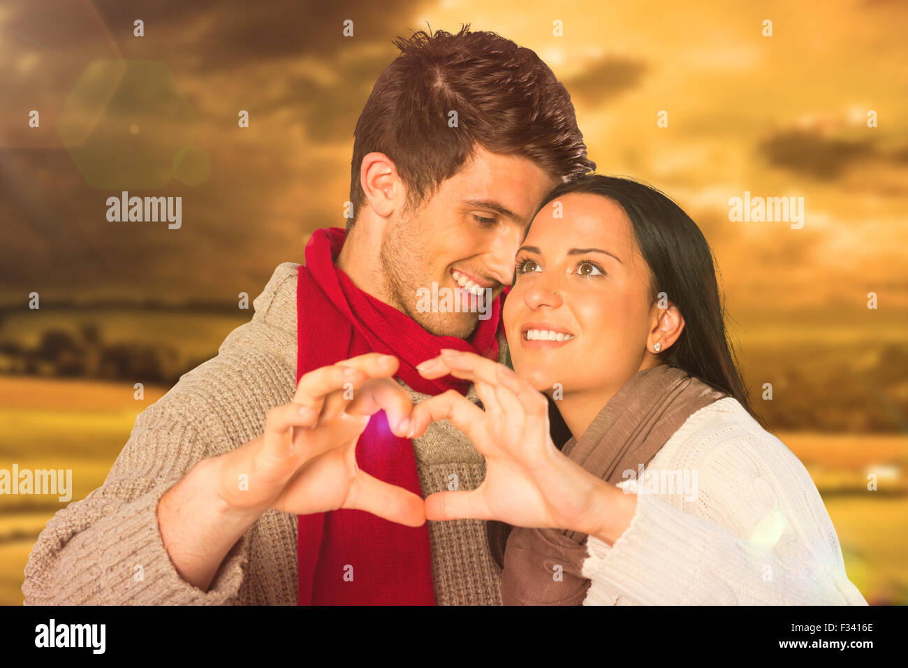 Composite image of young couple making heart with hands Stock Photo - Alamy