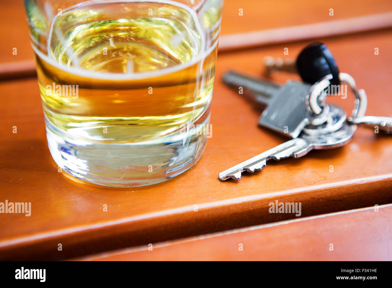 glass of beer on a table with a key next to it Stock Photo - Alamy