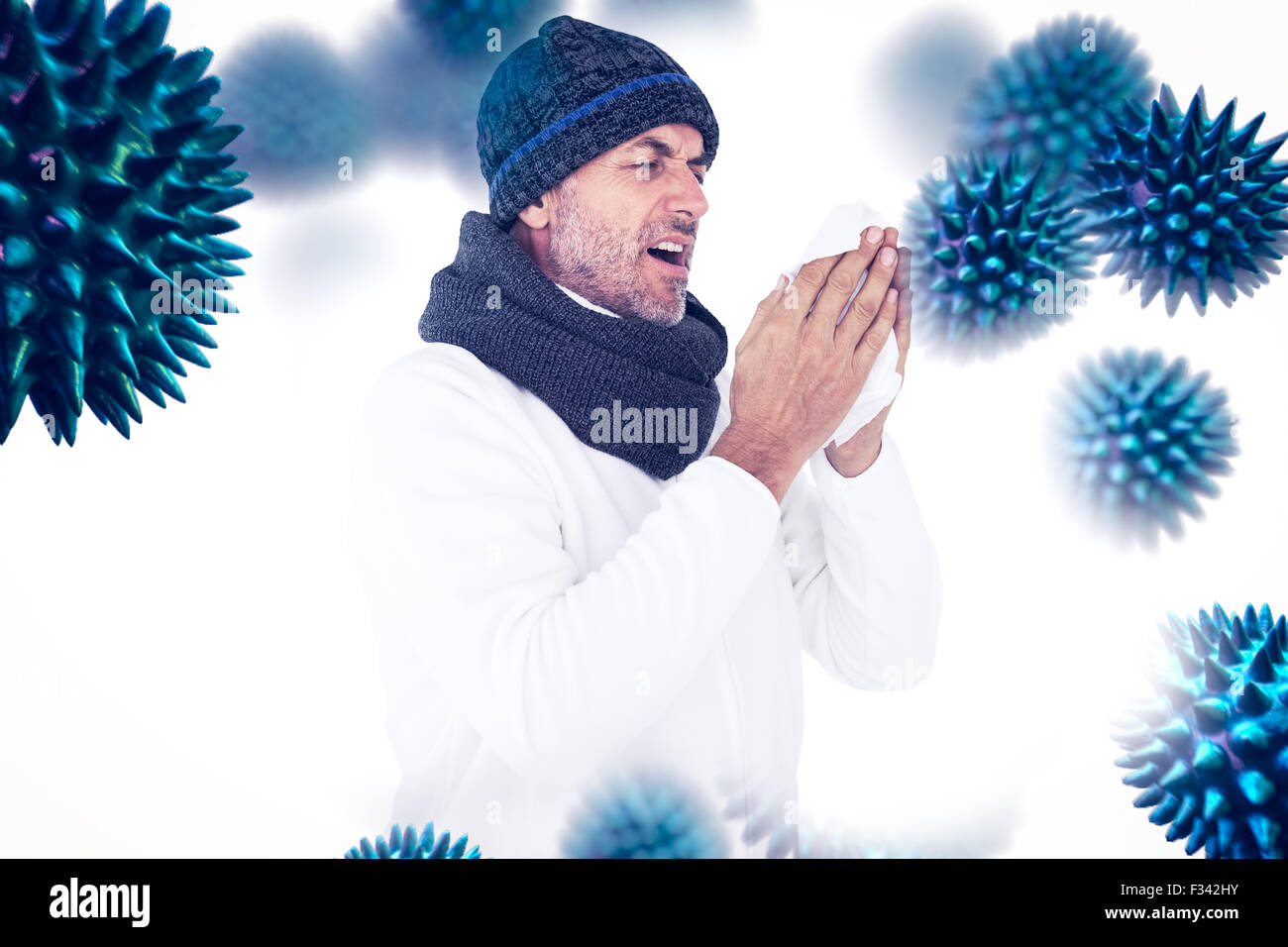 Composite image of sick man in winter fashion sneezing Stock Photo - Alamy