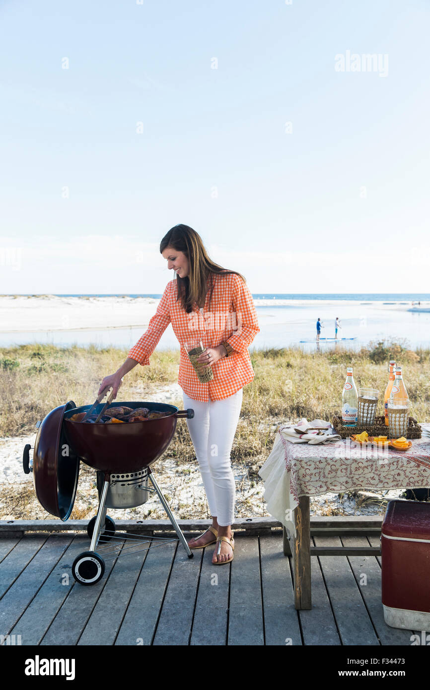 Woman grilling on the beach Stock Photo - Alamy