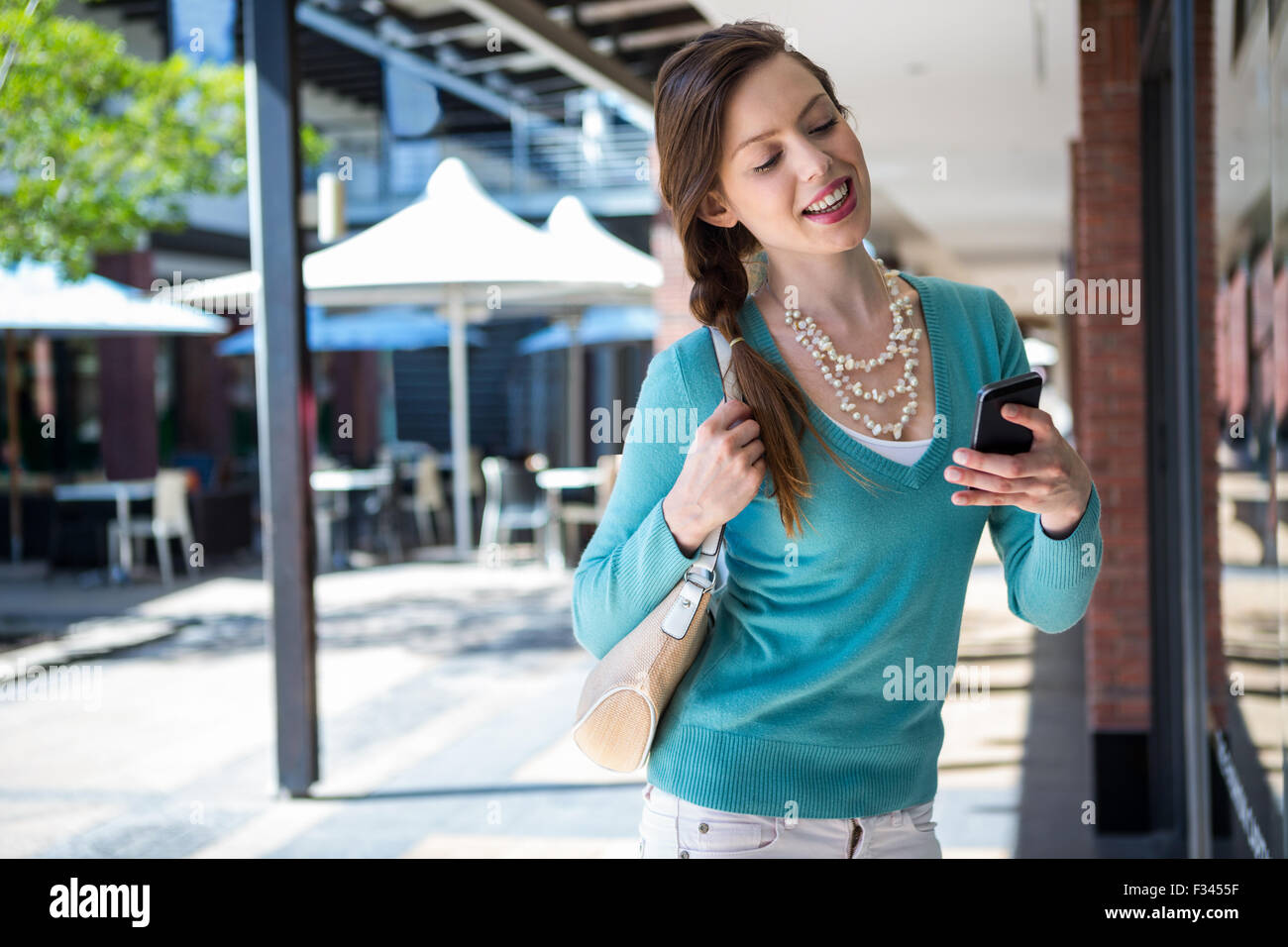 Brunette sending a text in the mall Stock Photo - Alamy