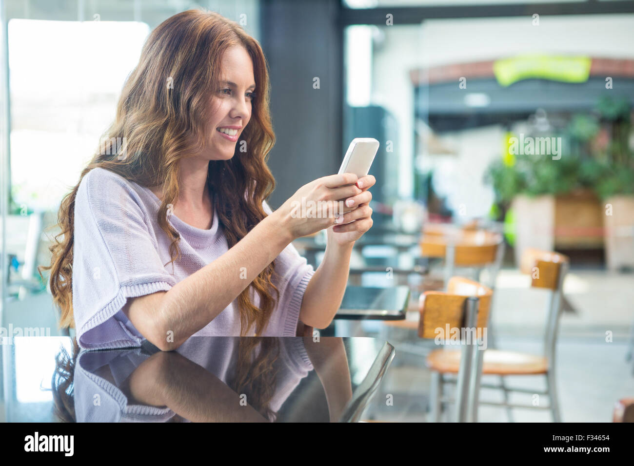 Pretty brunette sending a text Stock Photo - Alamy