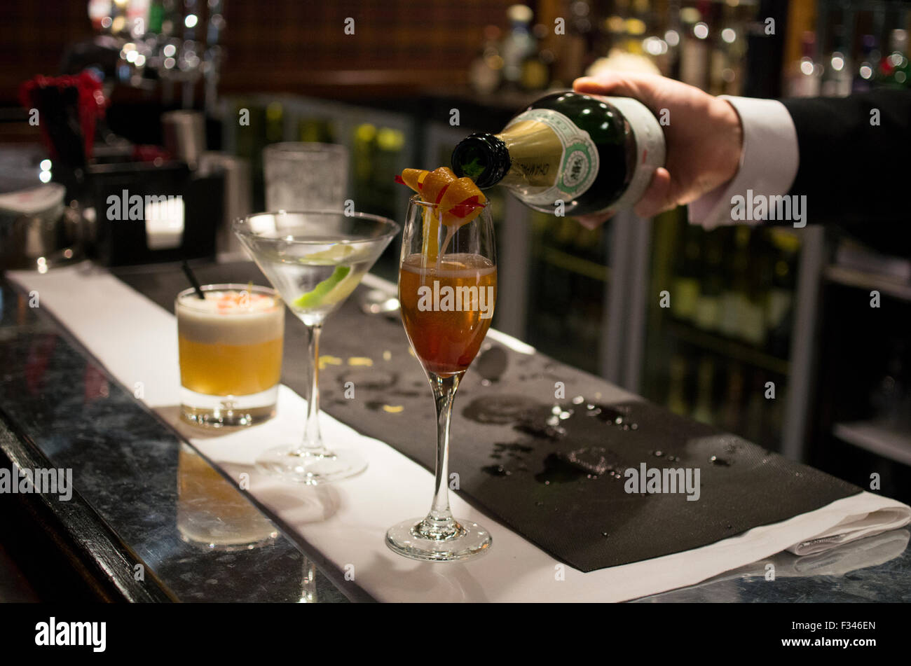 Making a martini, a whiskey sour and a champagne cocktail in a hotel ...