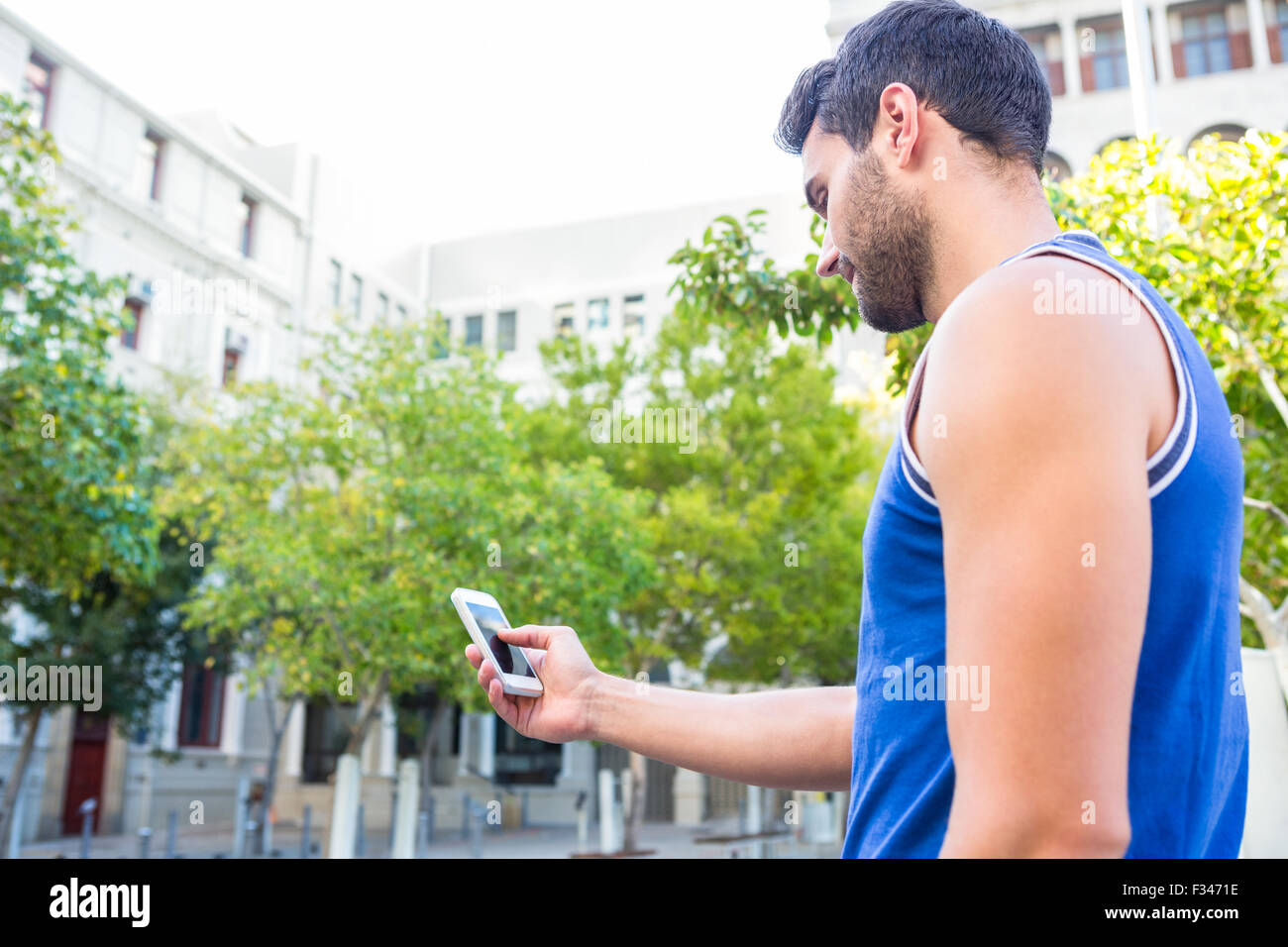 Handsome athlete using smartphone Stock Photo - Alamy