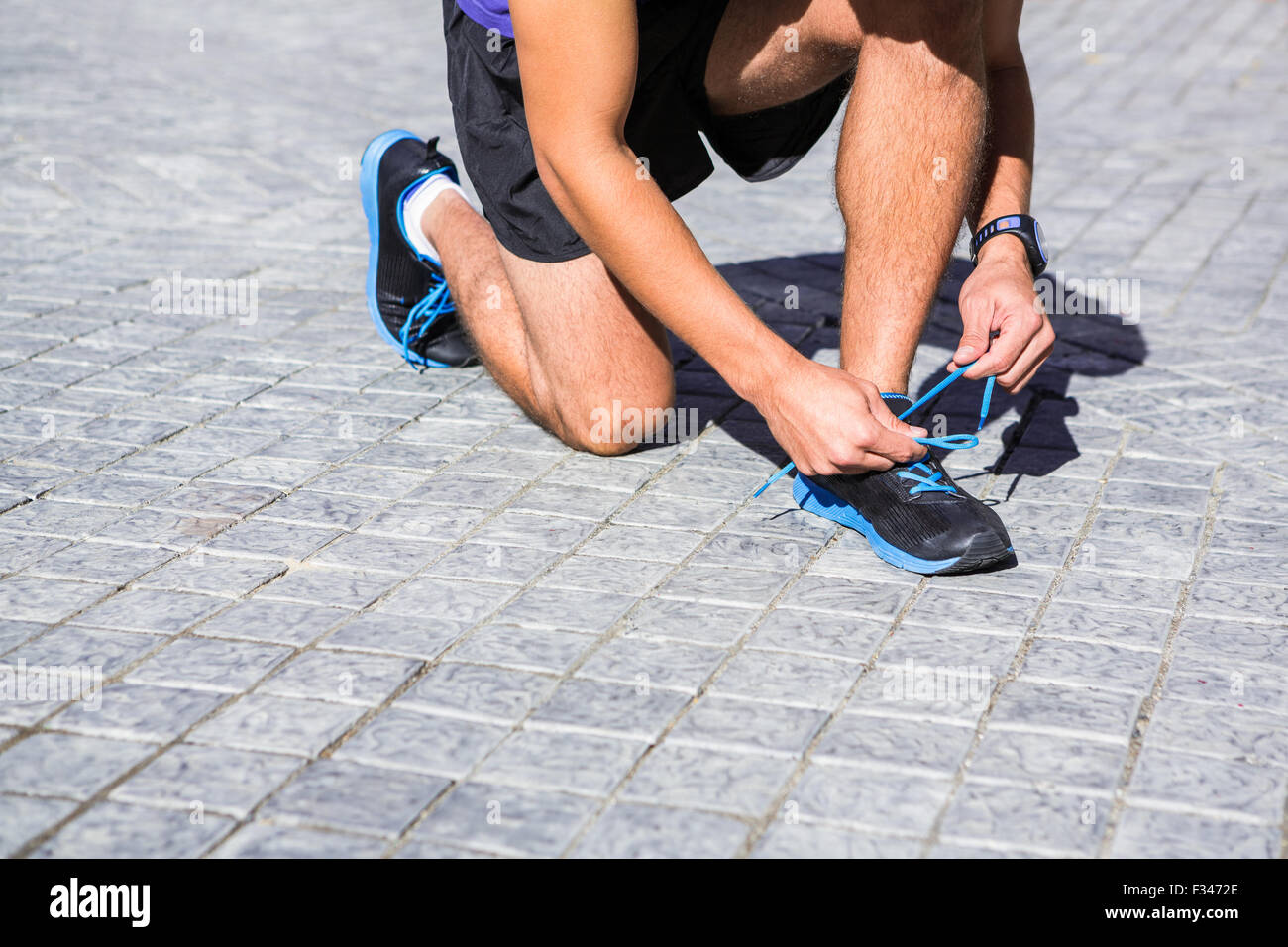 Athlete tying his shoes on a sunny day Stock Photo - Alamy