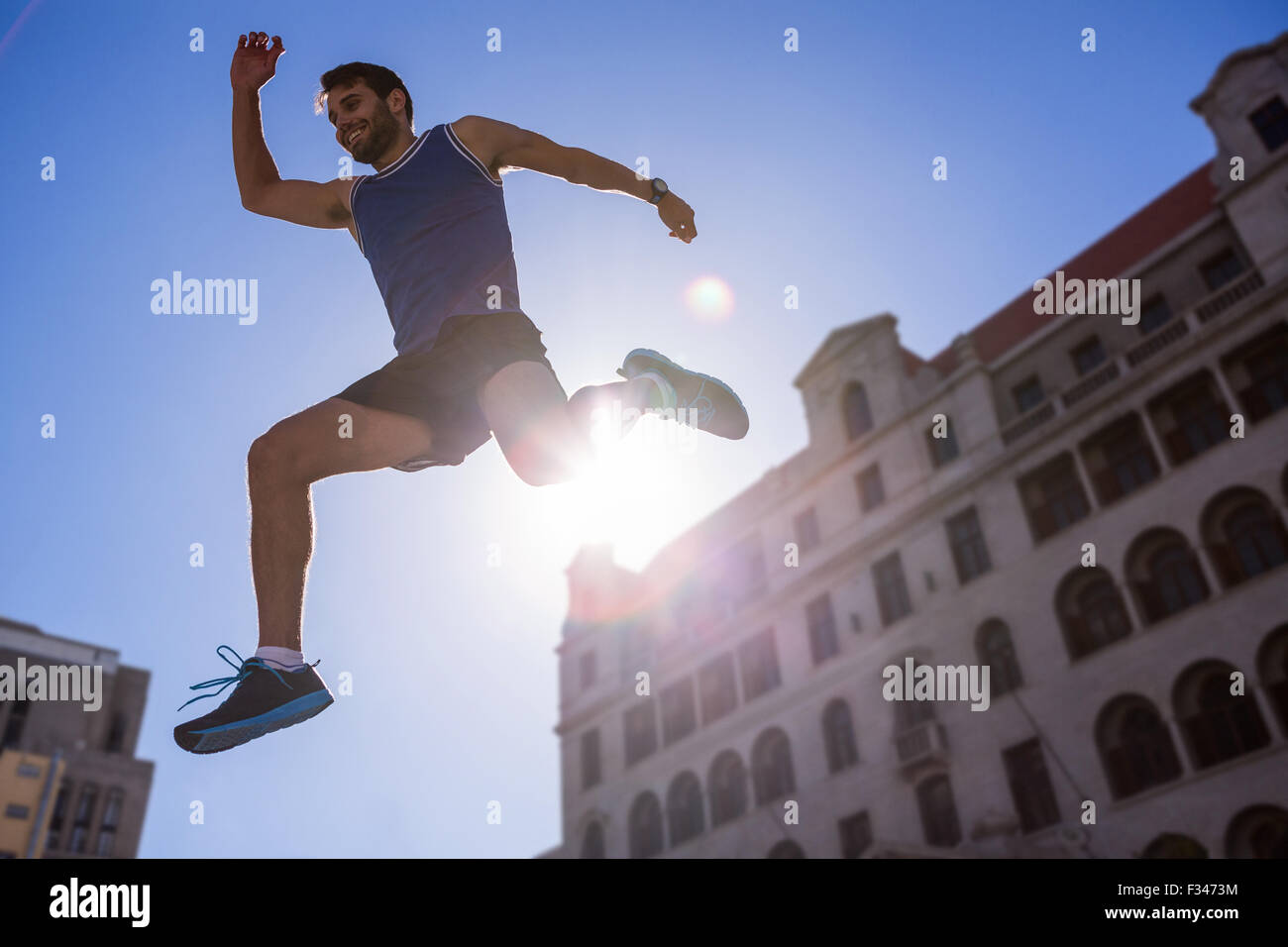 Handsome athlete leaping in front of building Stock Photo - Alamy