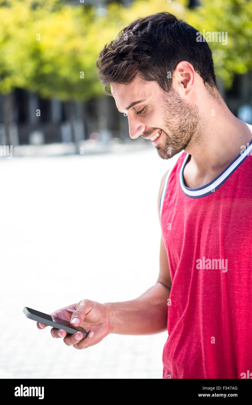 Smiling handsome athlete sending a text Stock Photo - Alamy