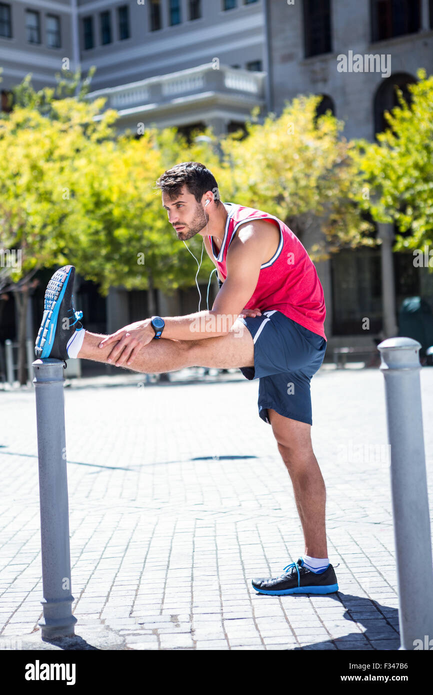 Handsome athlete doing leg stretching on a stake Stock Photo - Alamy