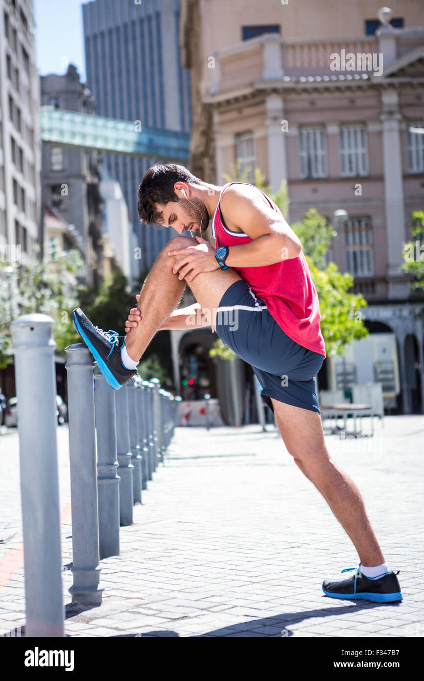 Handsome athlete doing leg stretching on a stake Stock Photo - Alamy