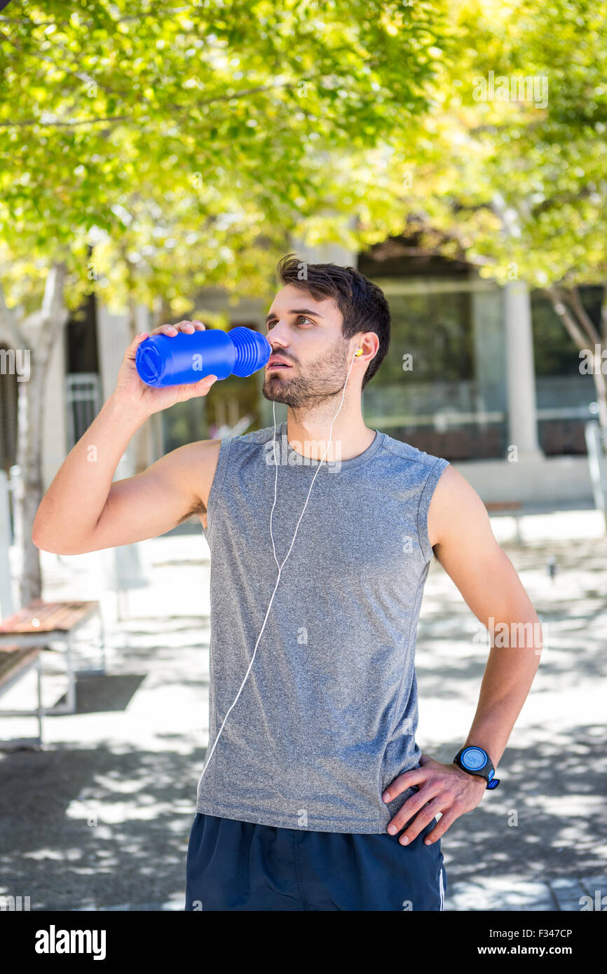 Handsome runner drinking water with hands on hips Stock Photo - Alamy