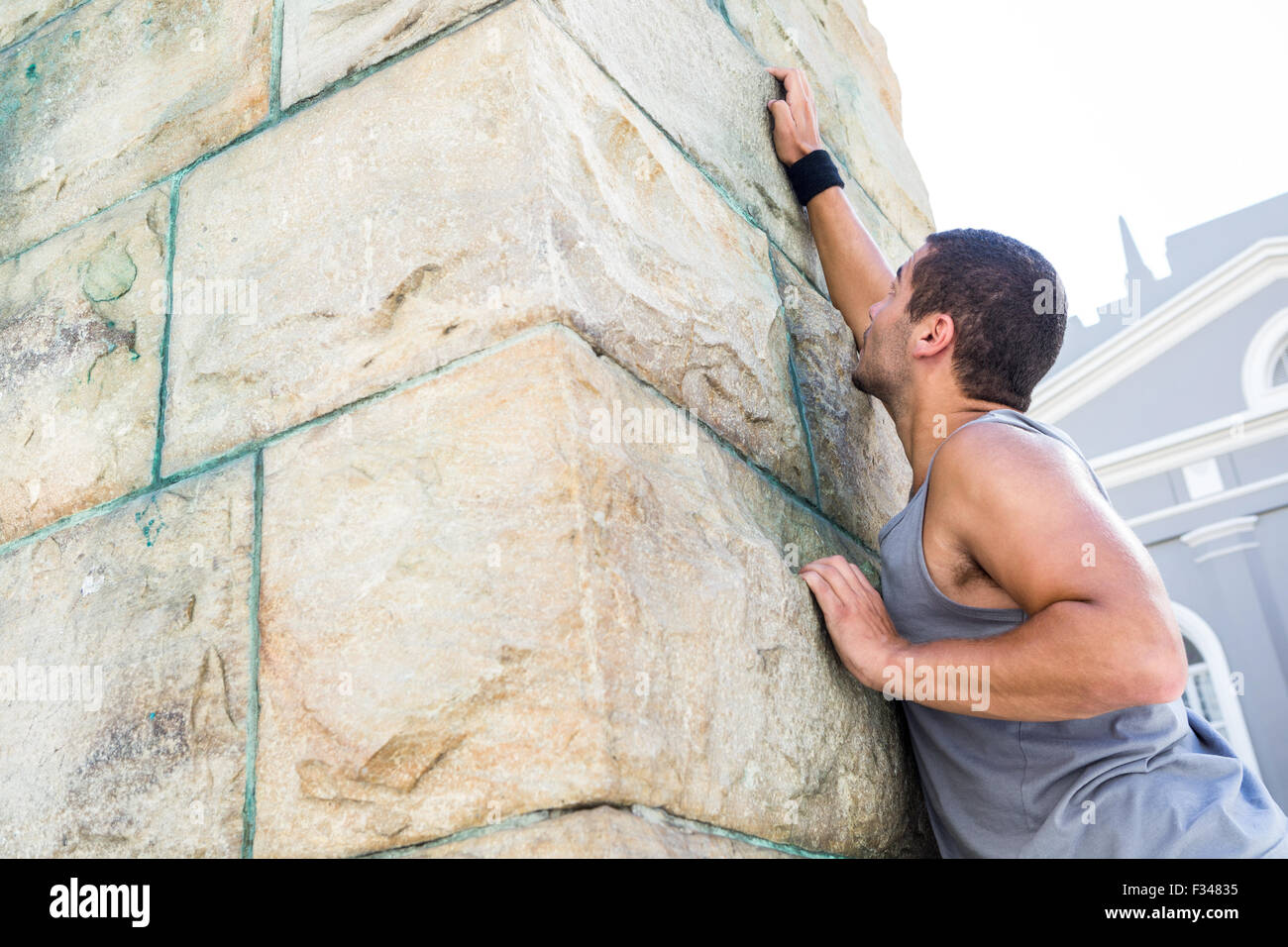 Extreme athlete gripping to wall Stock Photo - Alamy