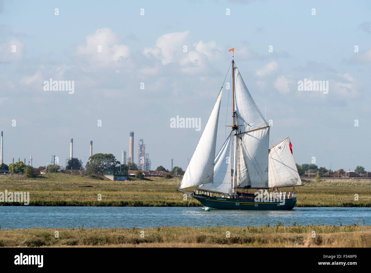 A sailing boat in full sail from Benfleet marina heading seawards with ...