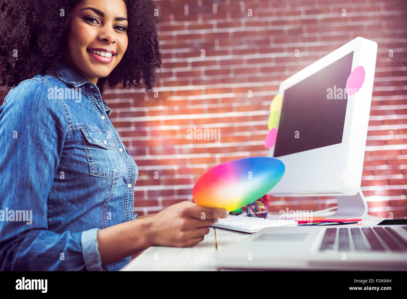 Casual female designer smiling and holding colour chart Stock Photo - Alamy