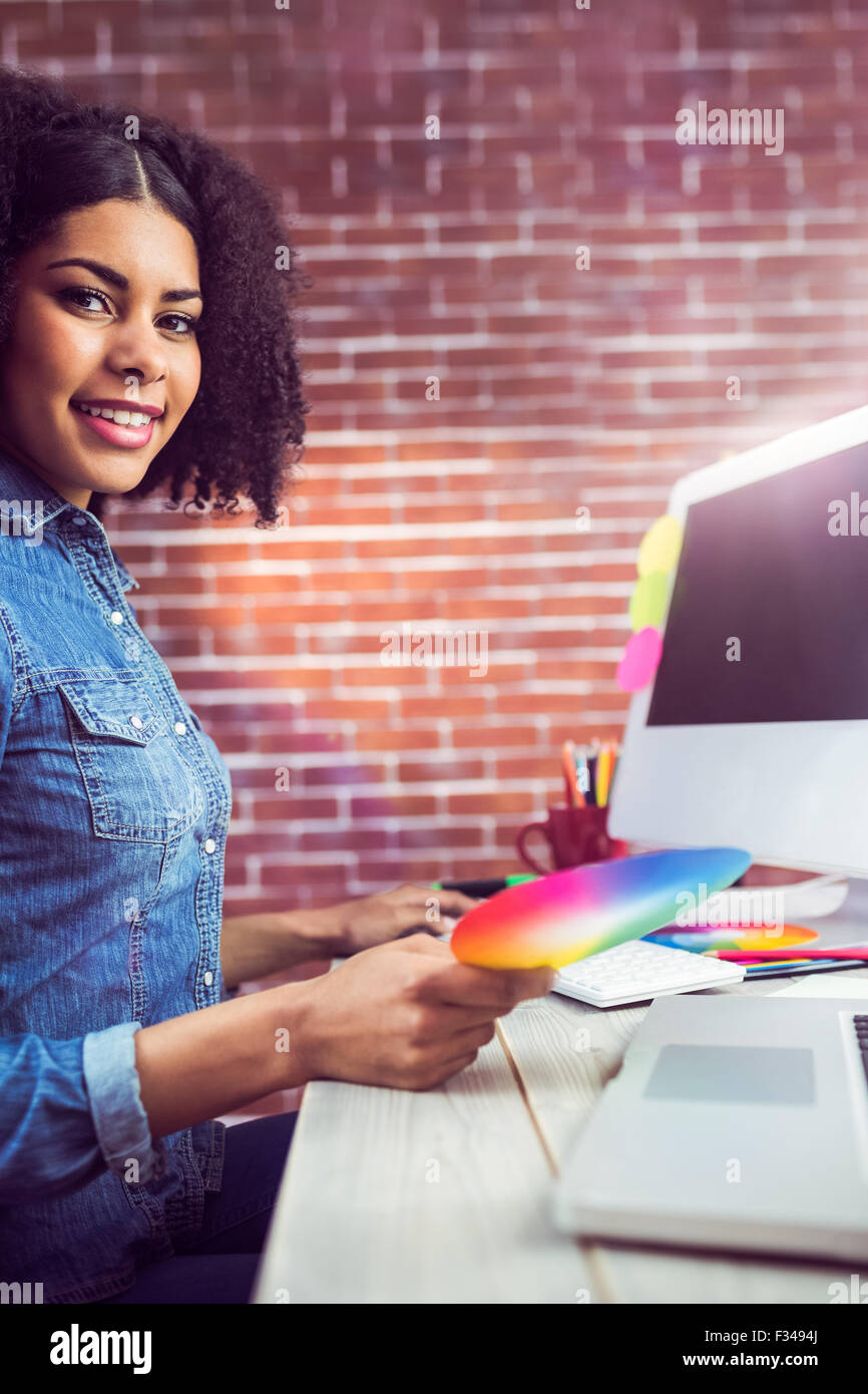 Casual female designer smiling and holding colour chart Stock Photo - Alamy