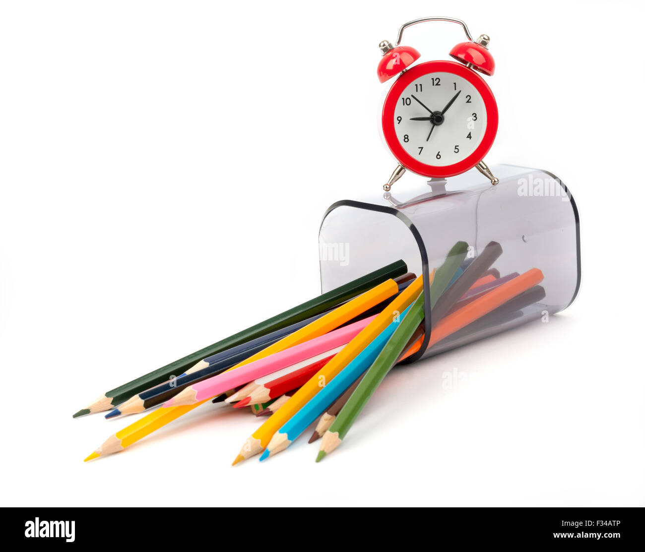 Fallen pencil cup with crayons and alarm clock Stock Photo - Alamy