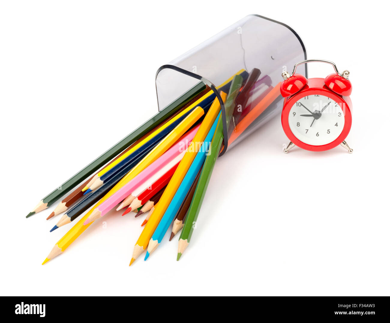 Fallen pencil cup with crayons and red alarm clock Stock Photo - Alamy