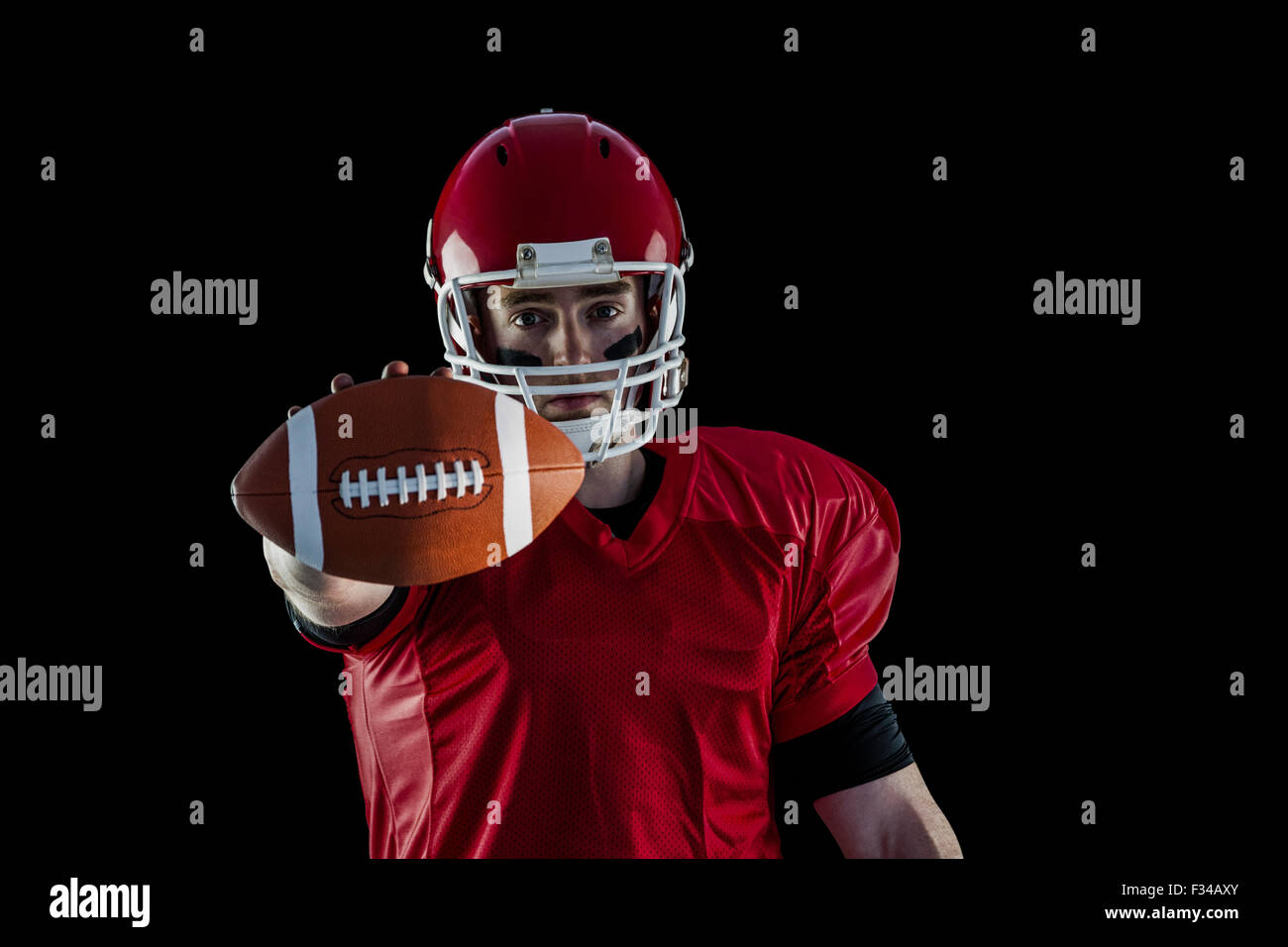 Portrait of american football player showing football to camera Stock ...