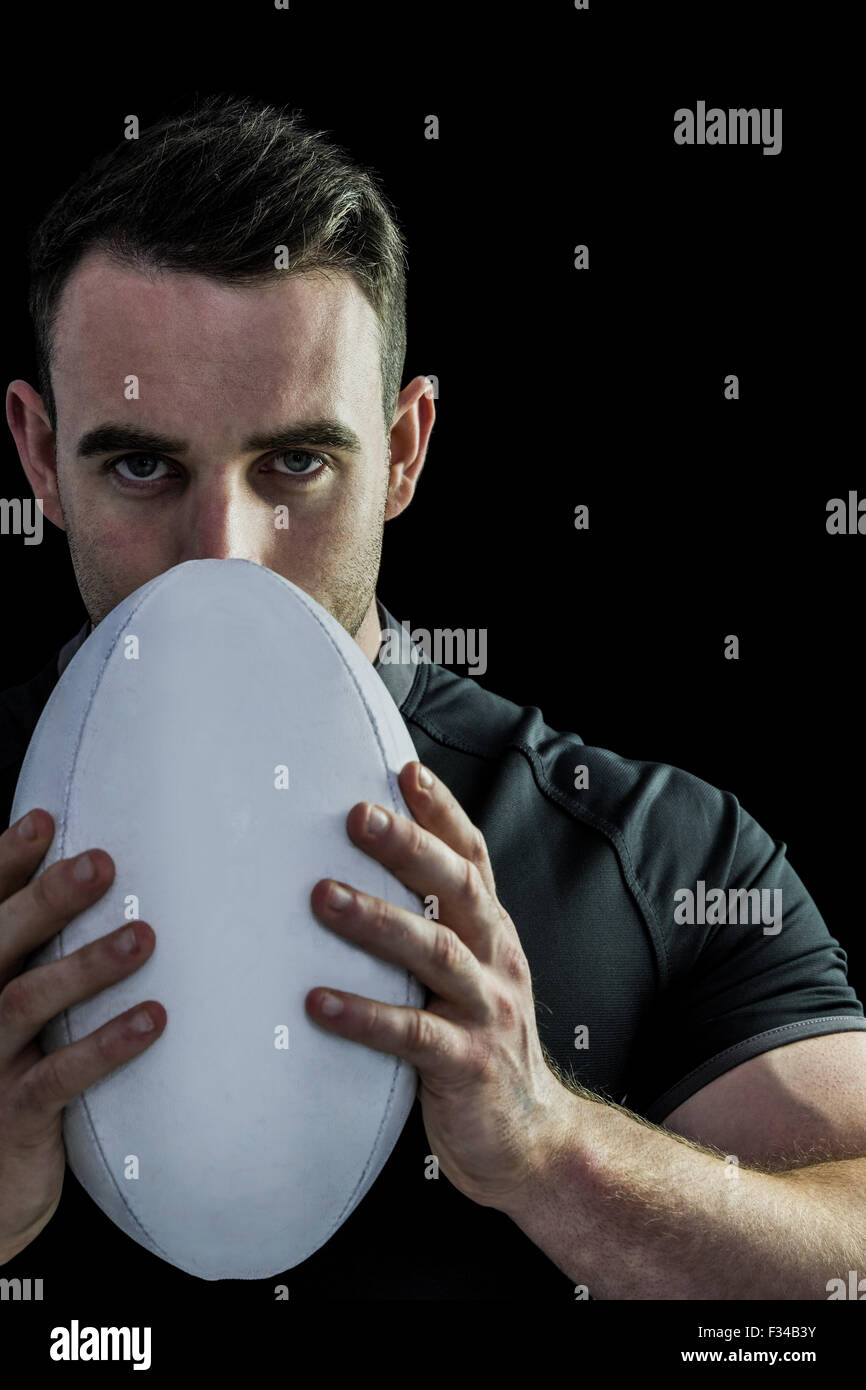 Tough rugby player holding ball Stock Photo - Alamy