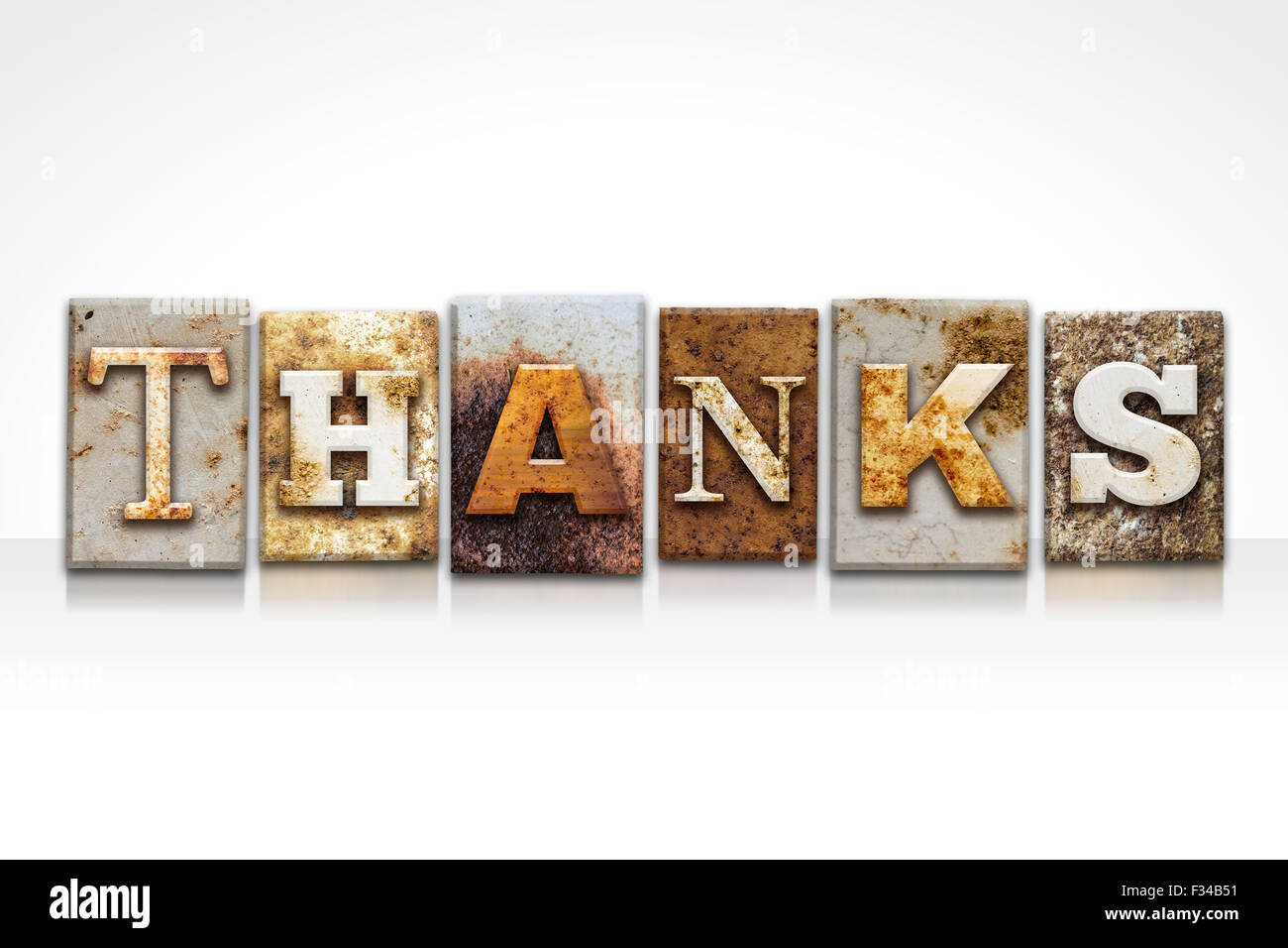 The word "THANKS" written in rusty metal letterpress type isolated on a ...