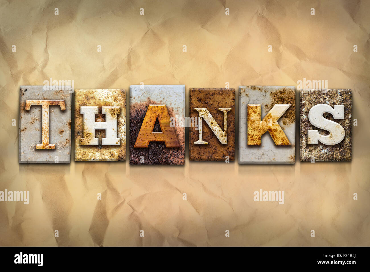 The word "THANKS" written in rusty metal letterpress type on a crumbled ...