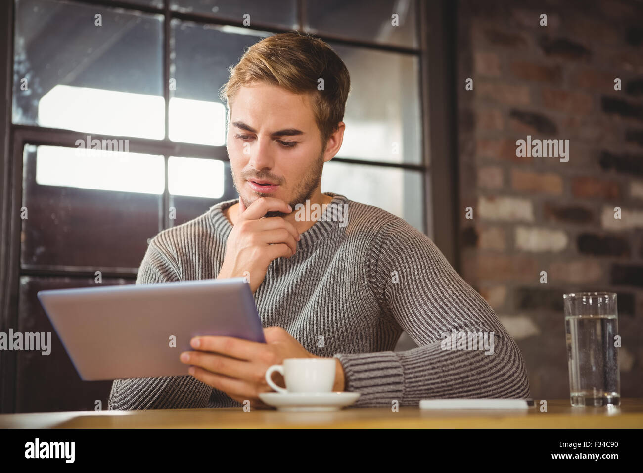 Handsome man focusing on tablet computer Stock Photo - Alamy