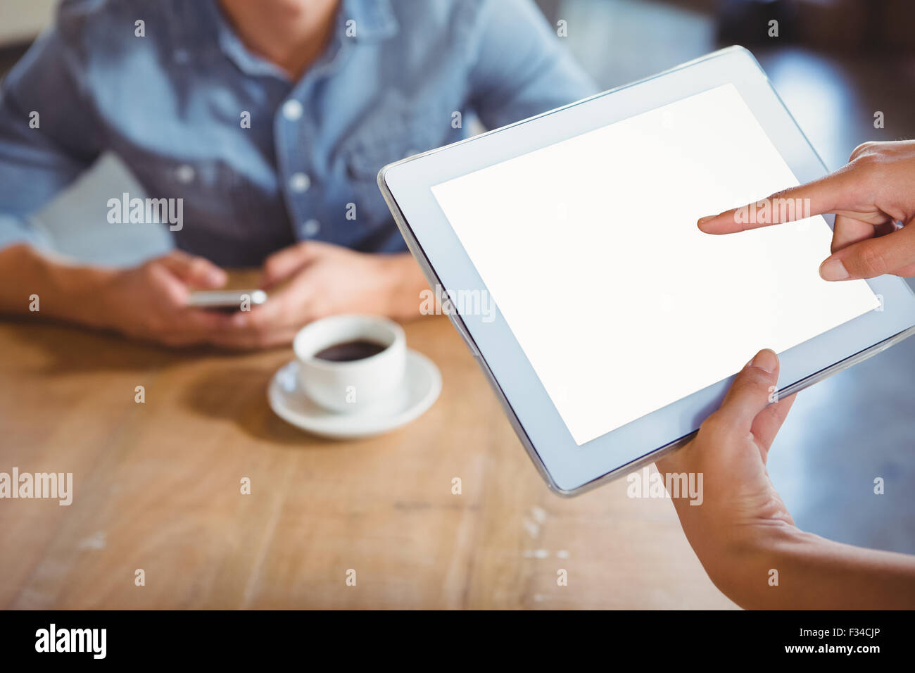 Smiling waitress using tablet pc Stock Photo - Alamy