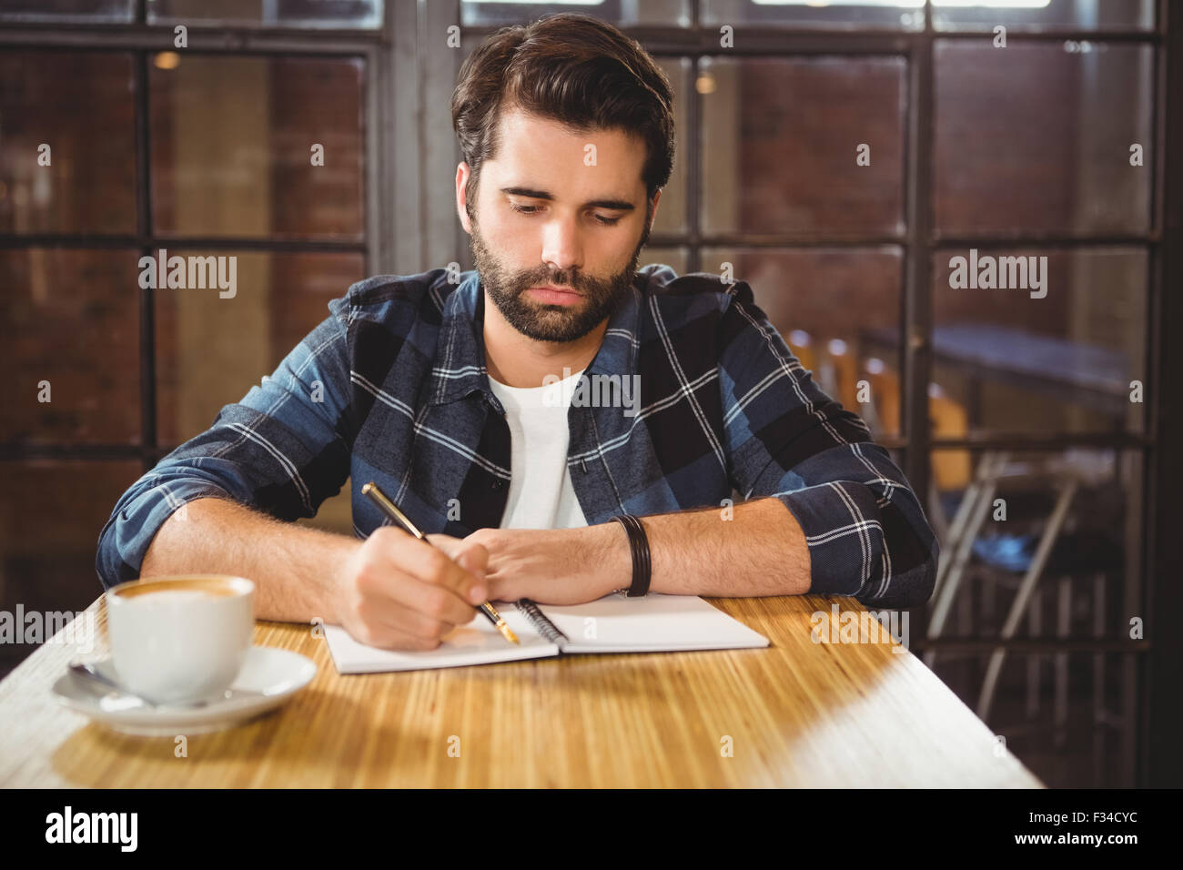 Young man taking notes in his notebook Stock Photo - Alamy