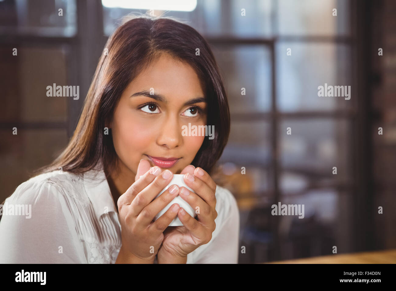 Beautiful woman drinking a coffee and looking away Stock Photo - Alamy