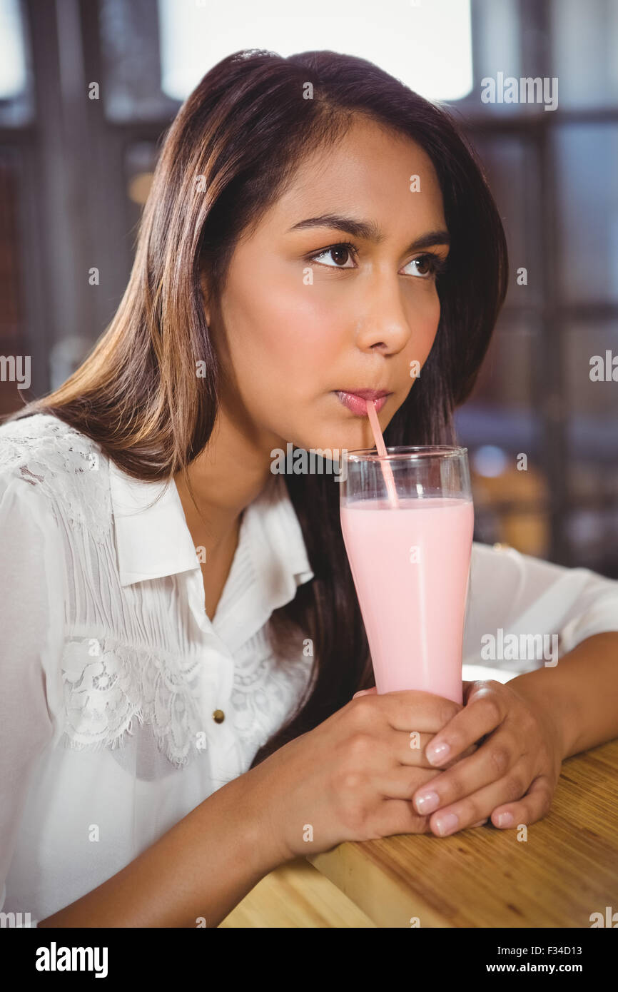 A beautiful woman drinking a pink milkshake Stock Photo - Alamy