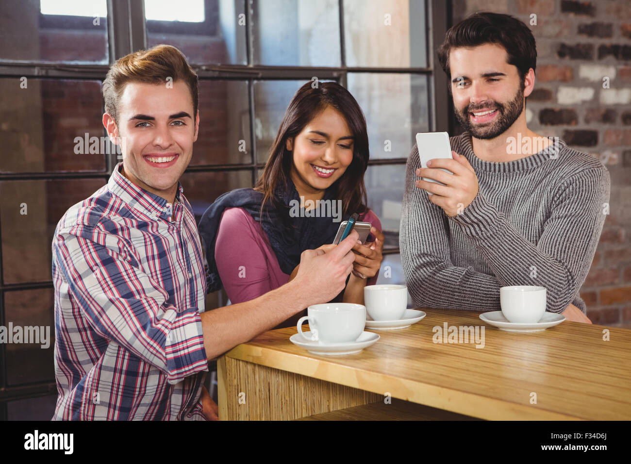 Group of friends looking at their smartphone Stock Photo - Alamy
